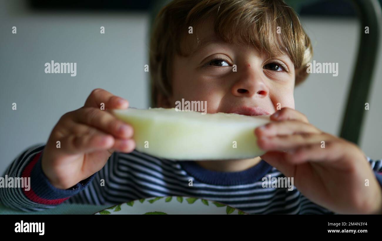 Child eating melon fruit hungry little boy eats healthy snack Stock ...