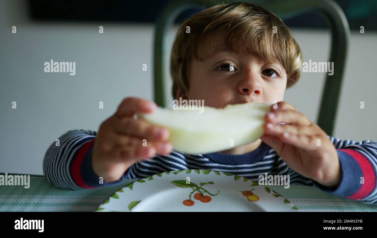 Child eating melon fruit hungry little boy eats healthy snack Stock ...