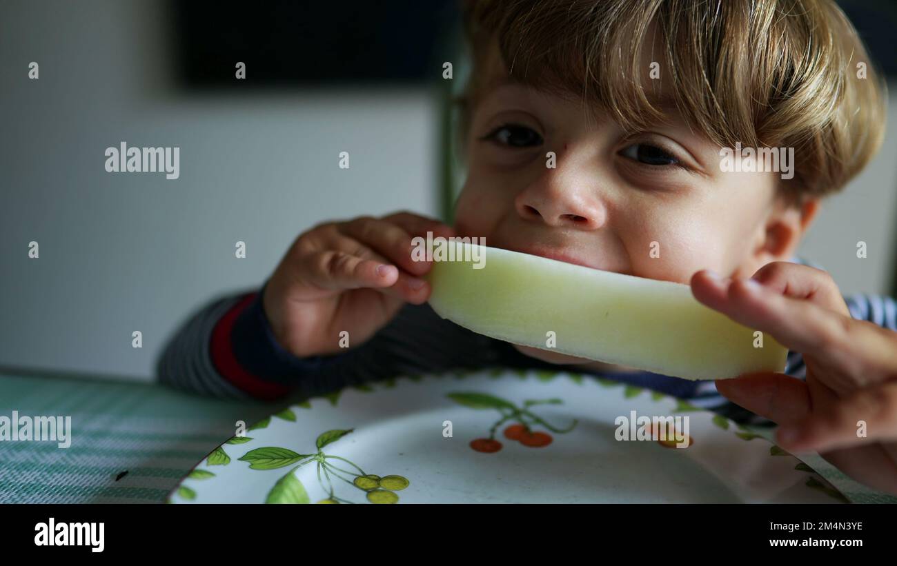Child eating melon fruit hungry little boy eats healthy snack Stock ...