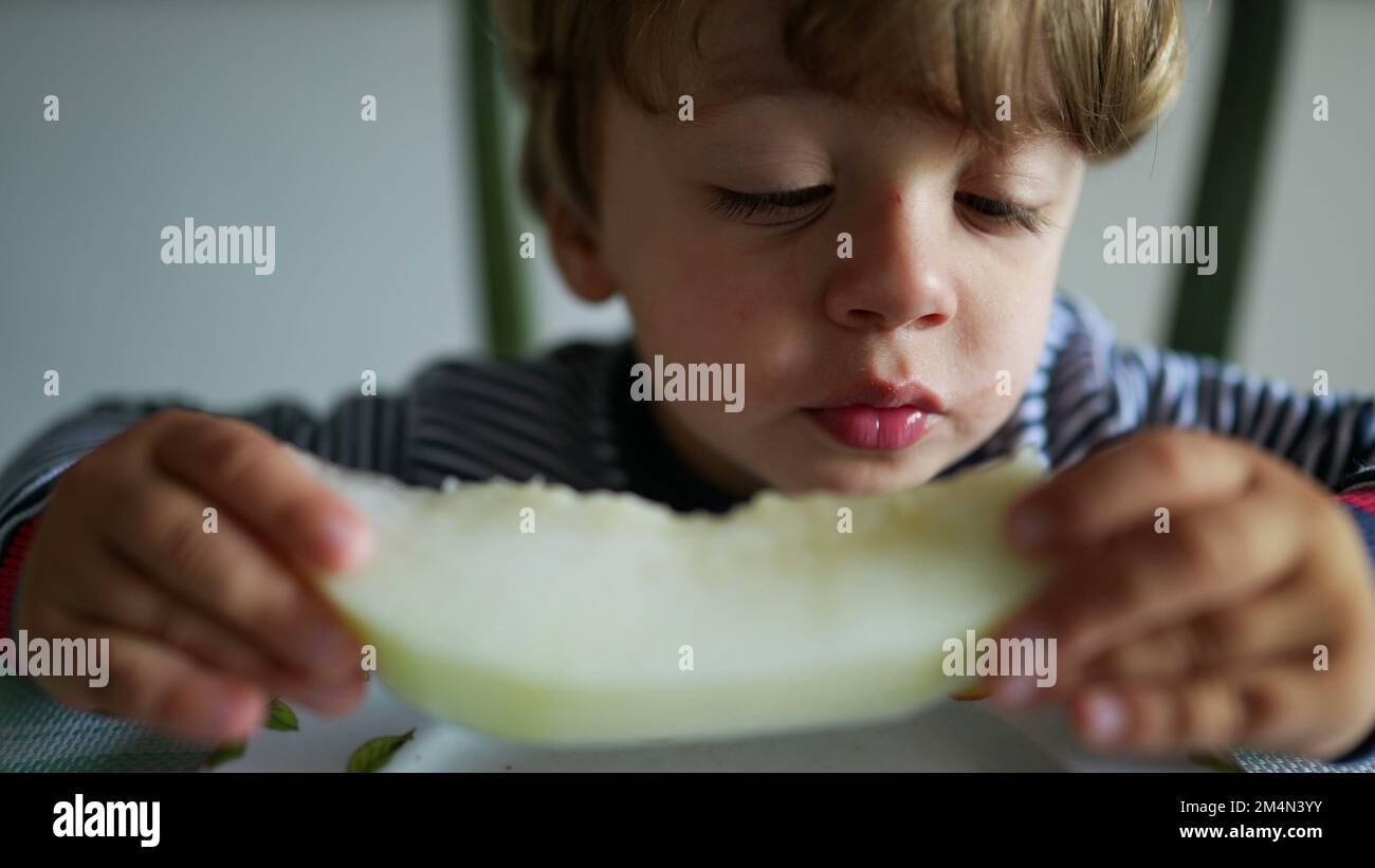 Child eating melon fruit hungry little boy eats healthy snack Stock ...