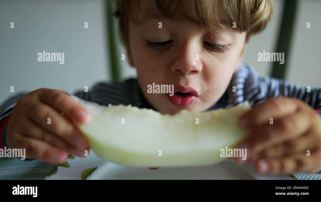 Child eating melon fruit hungry little boy eats healthy snack Stock ...