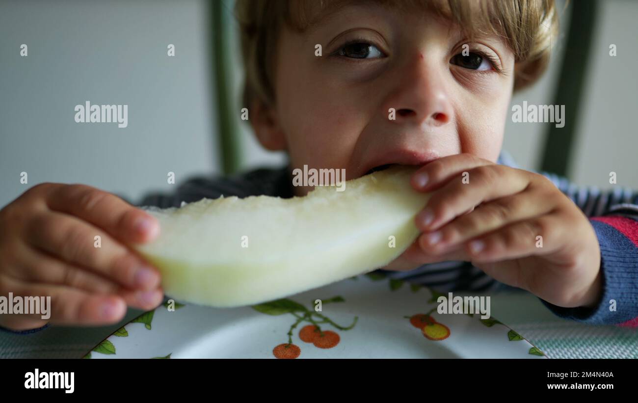 Child eating melon fruit hungry little boy eats healthy snack Stock ...