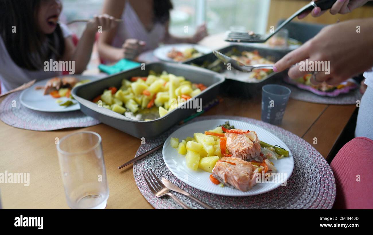 Family eating lunch at home. Mother and daughter seated around food ...