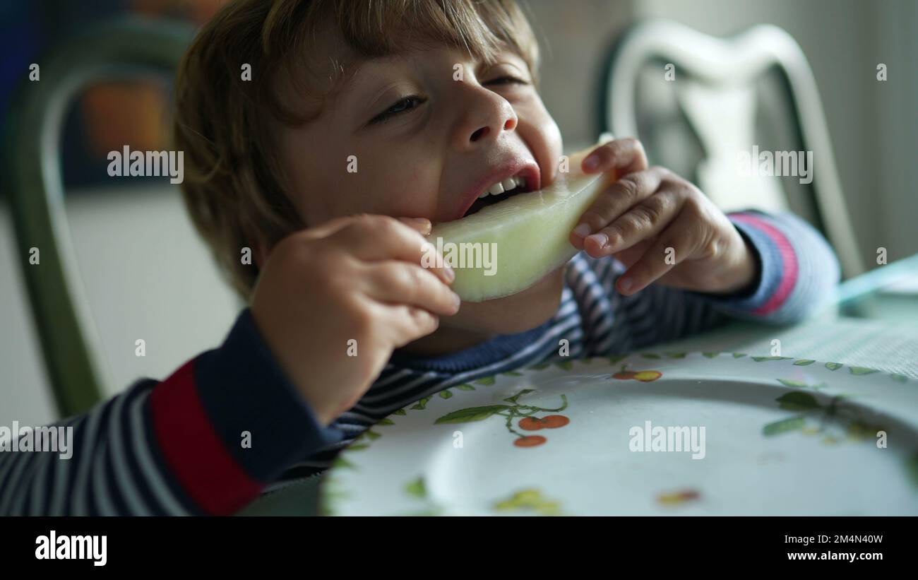 Child eating melon fruit hungry little boy eats healthy snack Stock ...