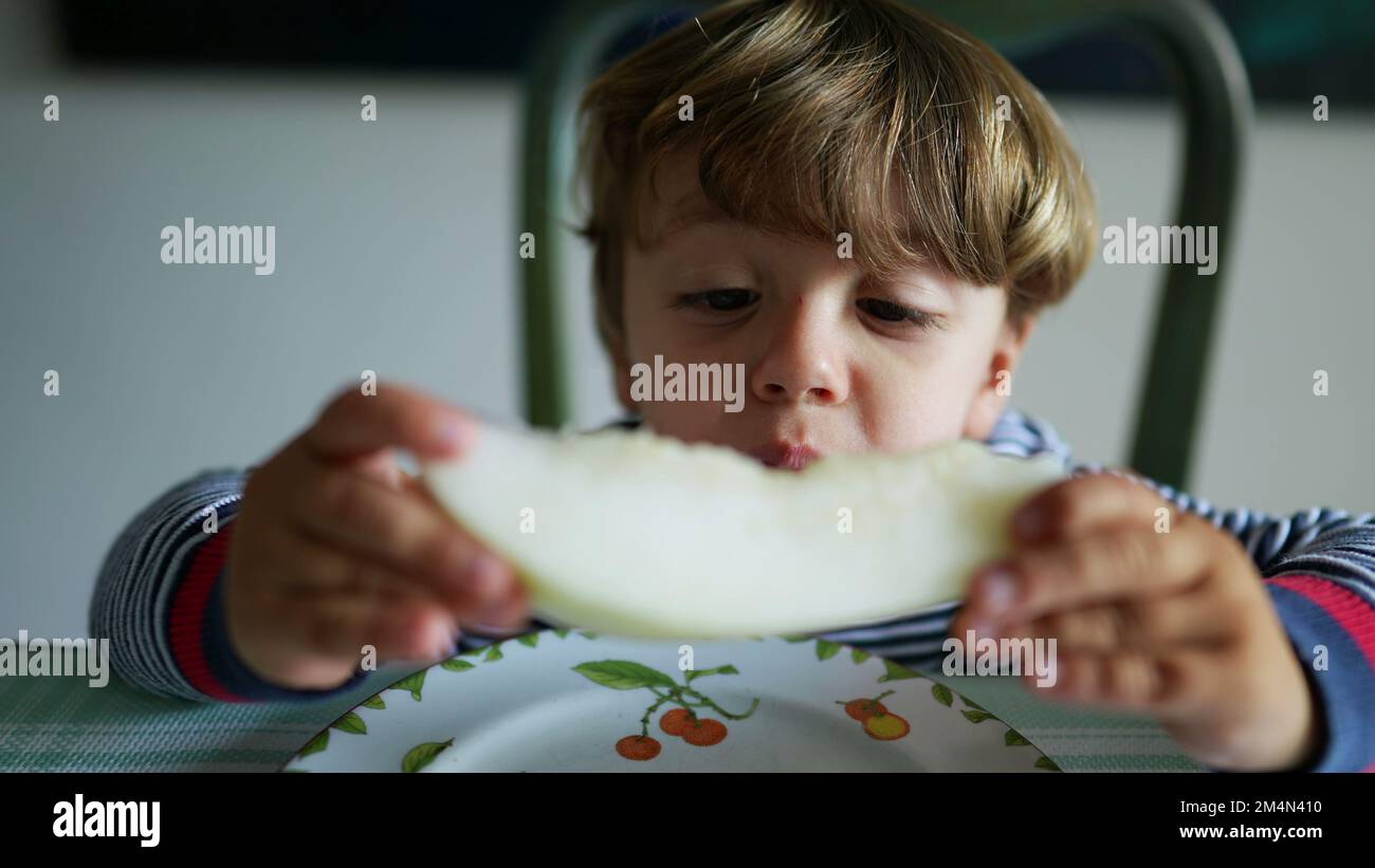 Child eating melon fruit hungry little boy eats healthy snack Stock ...