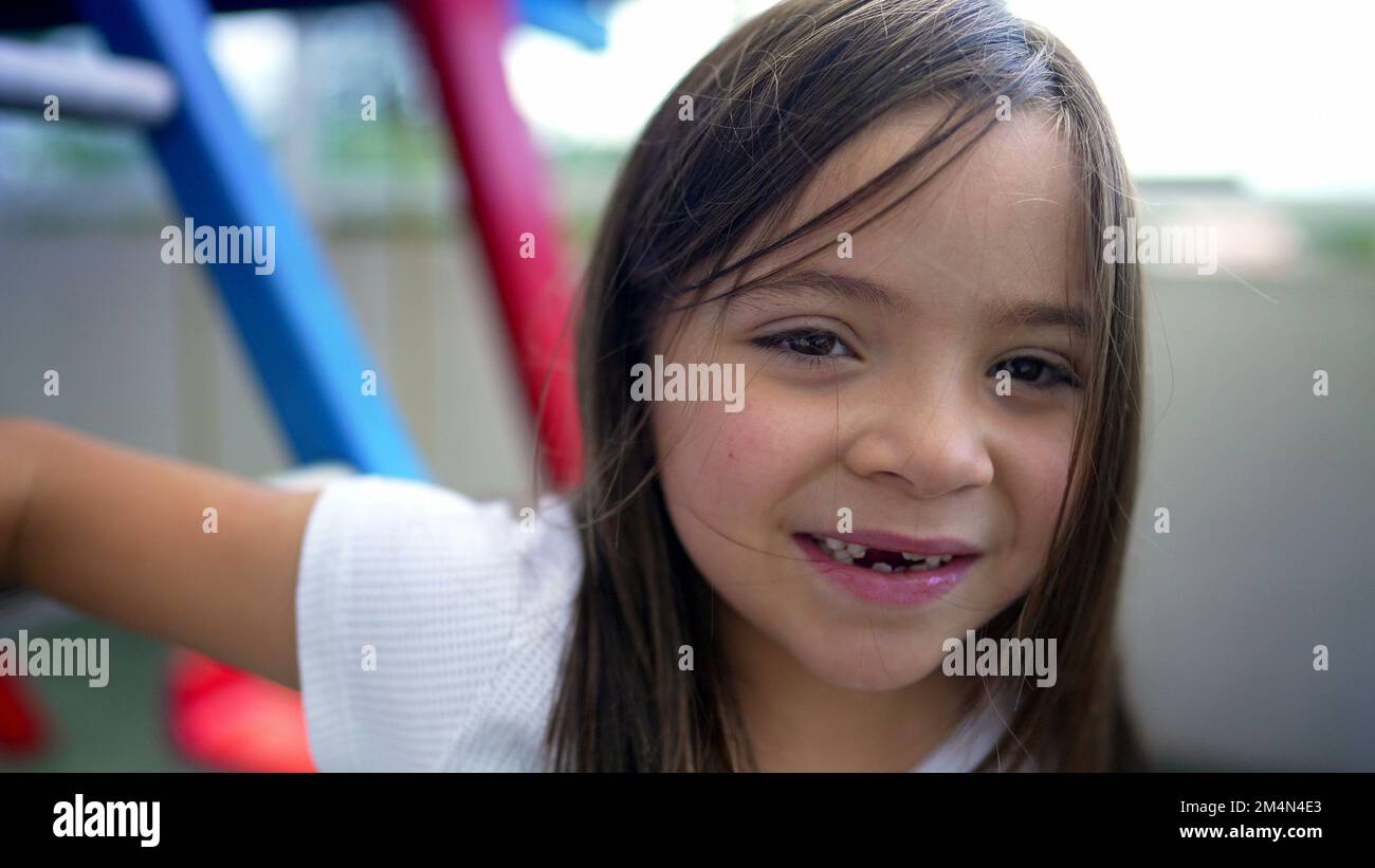 Portrait of a happy little girl closeup face with missing teeth. Joyful female child toothless ...