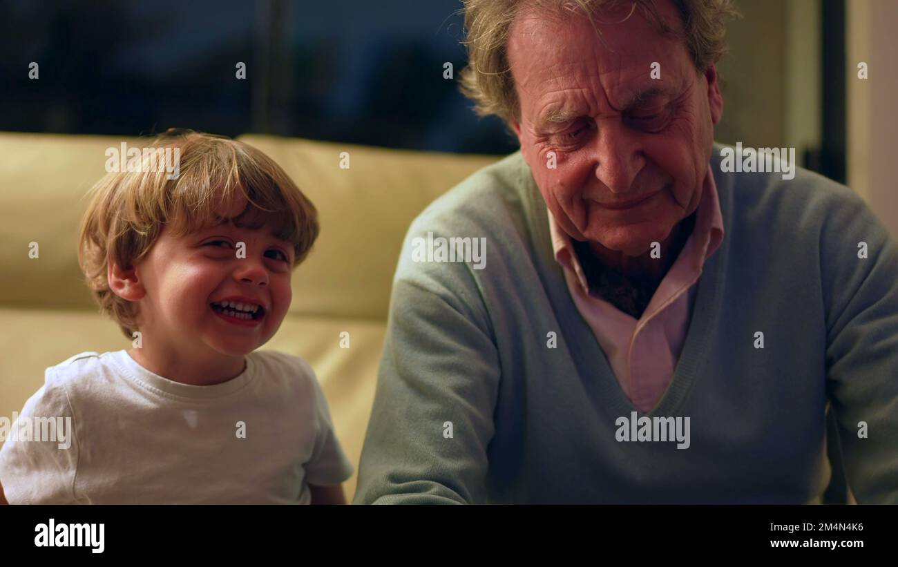 Grandfather and grandson hanging out together in living room couch ...
