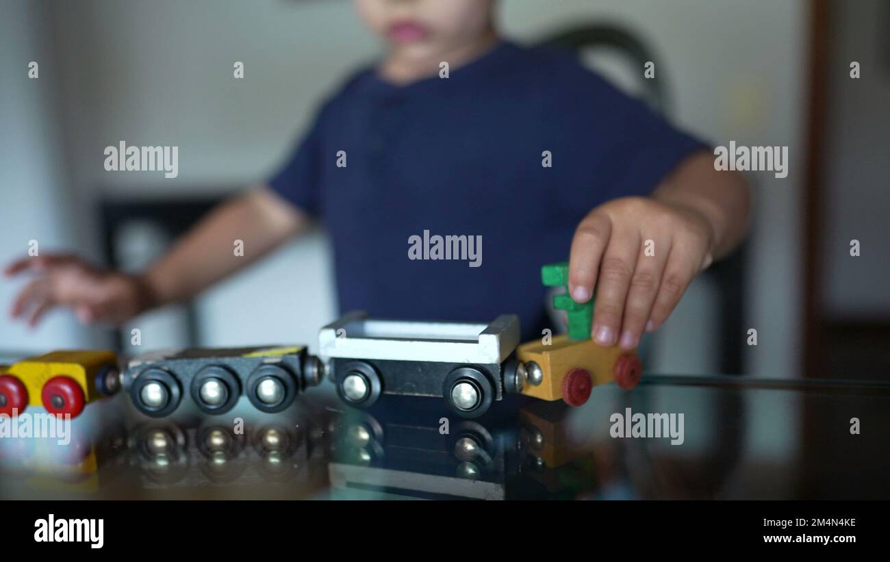 Small boy playing with toys. Child plays alone at home with traditional ...