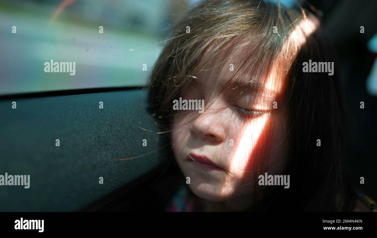 Small girl child closing eyes while traveling by car transportation ...