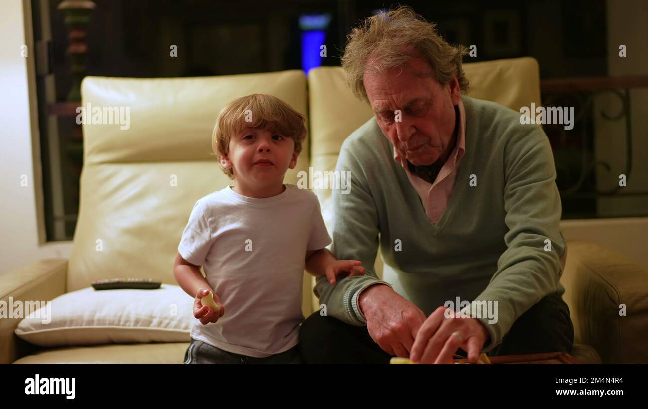 Grandfather and grandson hanging out together in living room couch ...