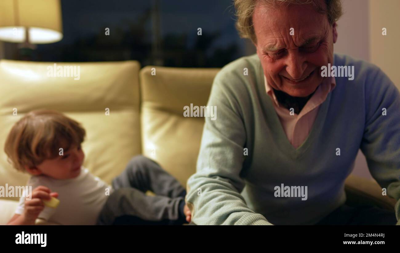 Grandfather and grandson hanging out together in living room couch ...