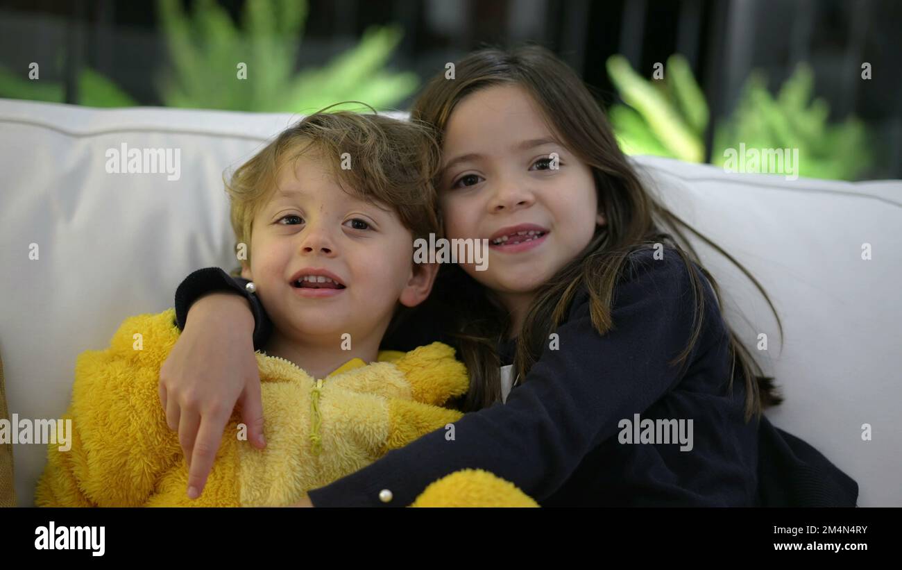 Happy little siblings posing for camera. Child sister embracing small ...