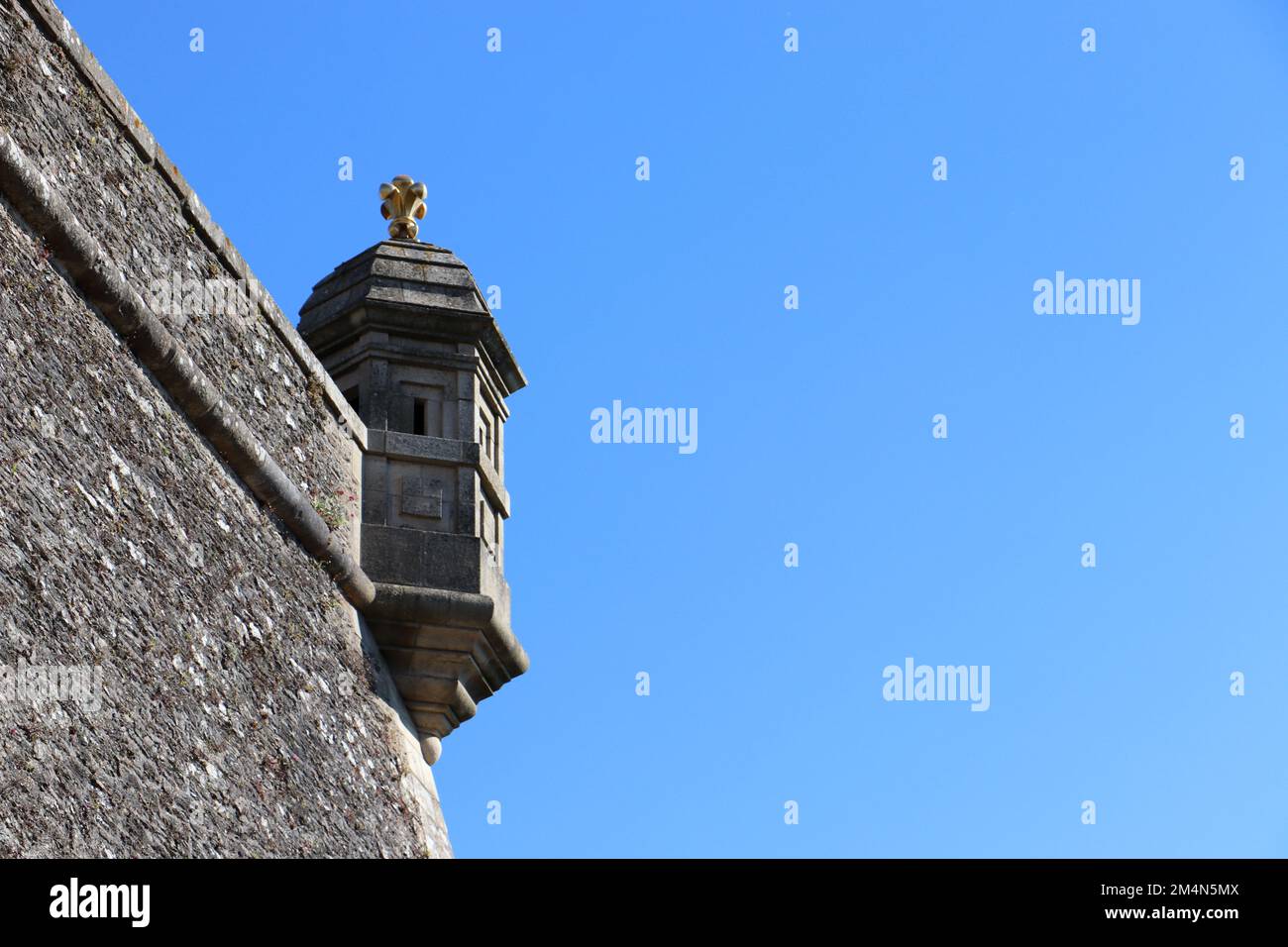 A low angle shot of a castle corner tower under the blue sky on a sunny ...