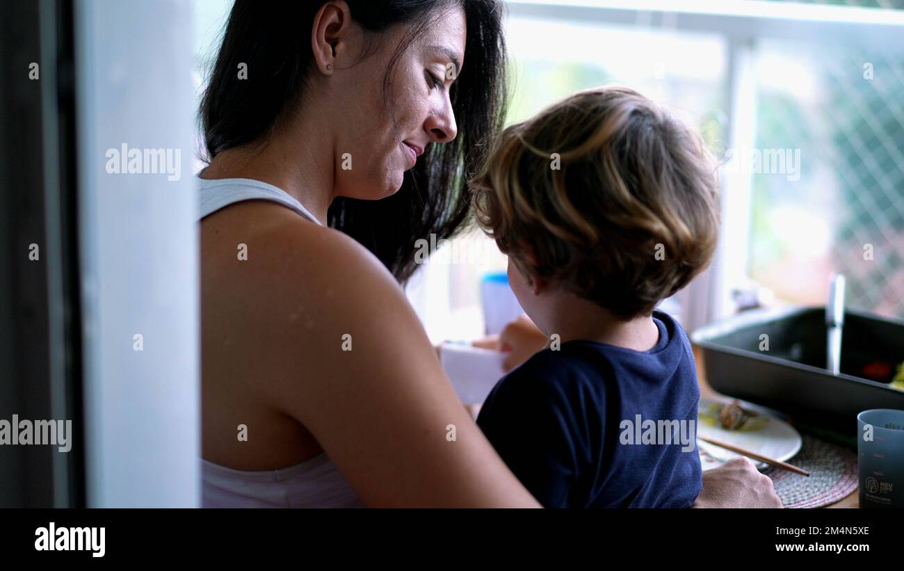 Mother and small boy child love and affection. Candid mom embracing kid in arms. Authentic real ...