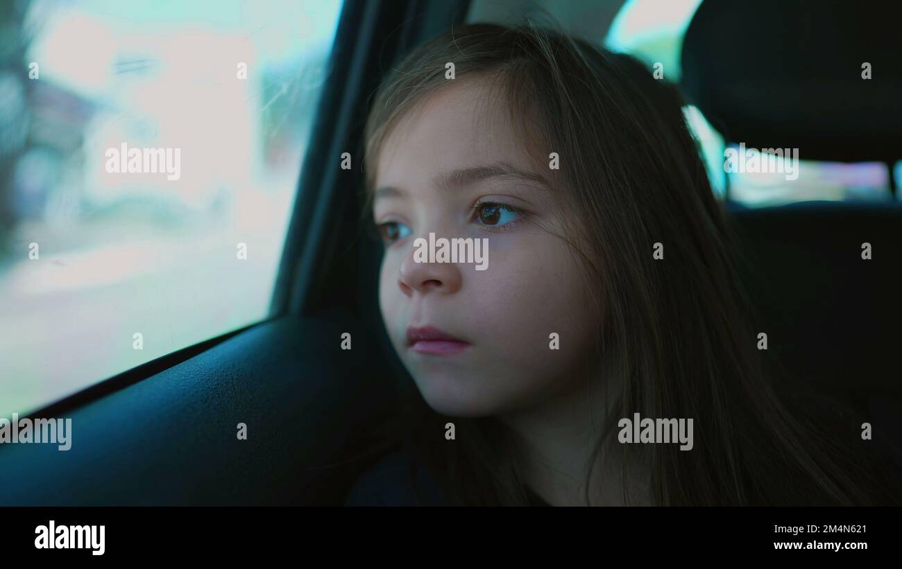 Pensive little girl in car backseat. One thoughtful child closeup face ...