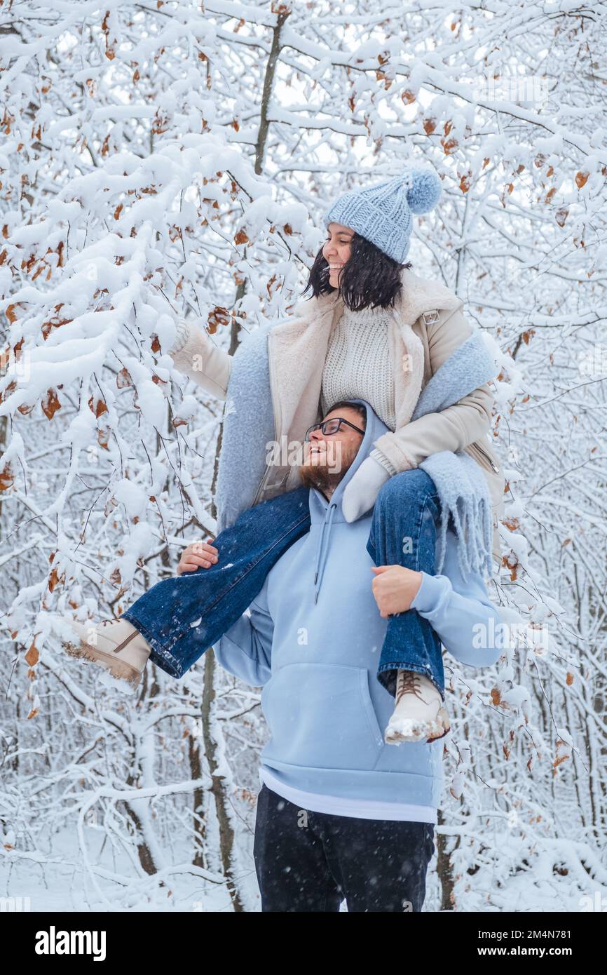 A woman rides on a man's shoulders in a snowy forest Stock Photo - Alamy
