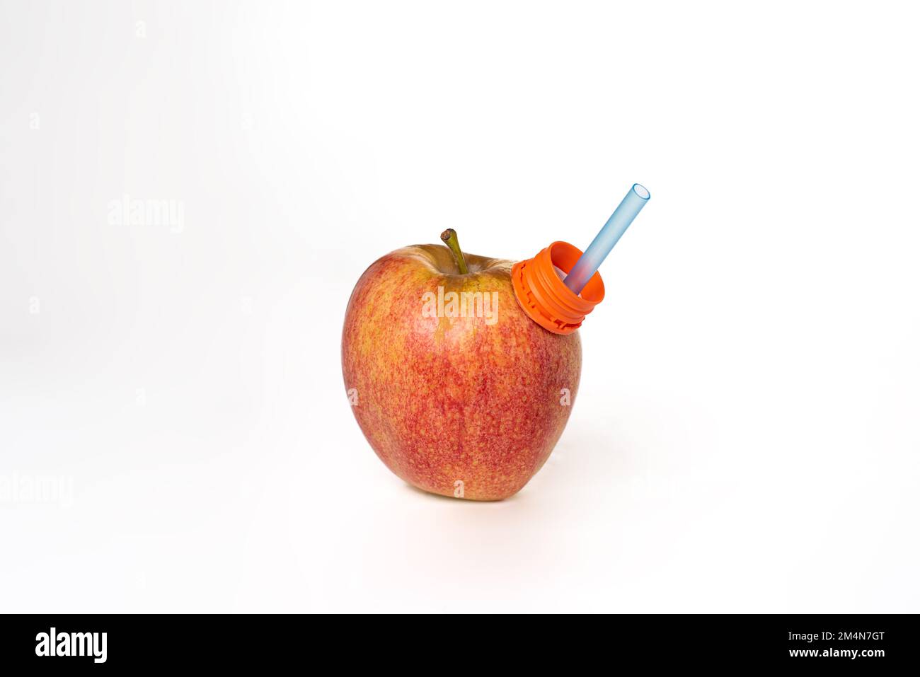 Apple, fruit on a white background, with a straw in the spout to be ...