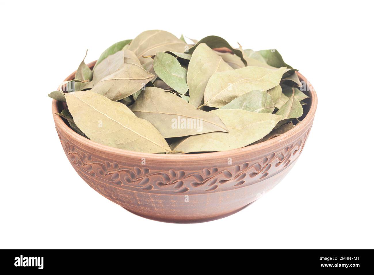 Dry bay leaves in a clay bowl isolated on white. Dried laurel leaf ...