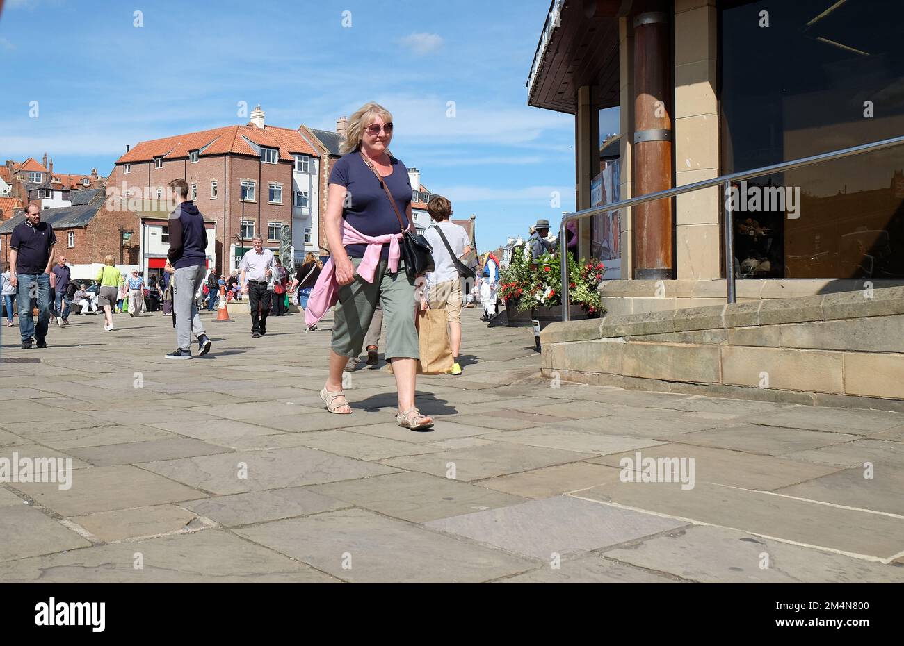 Middle aged woman walking on a sidewalk Stock Photo - Alamy