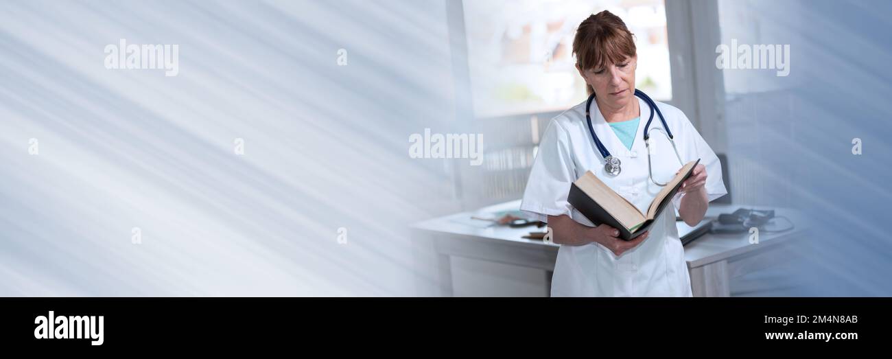 Female doctor reading a textbook in medical office; panoramic banner ...