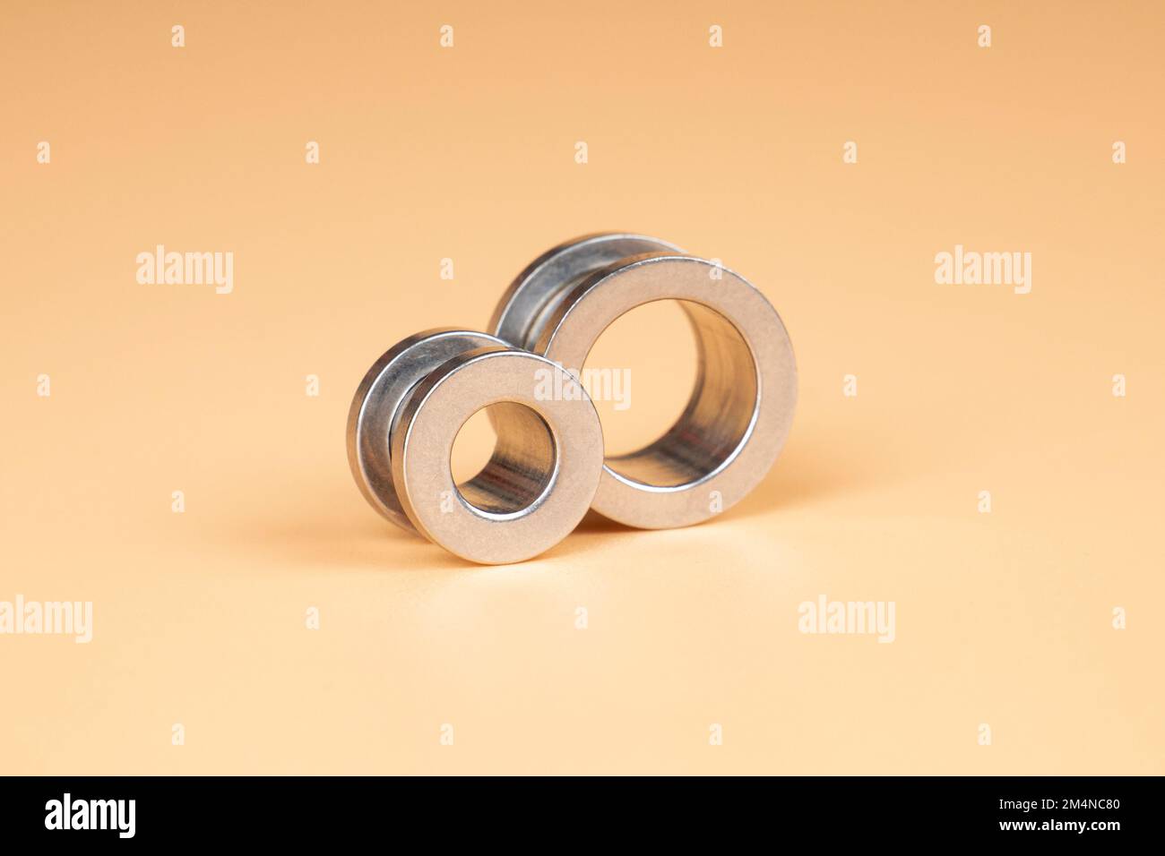 silver tunnel piercing accessory close up on beige background Stock ...