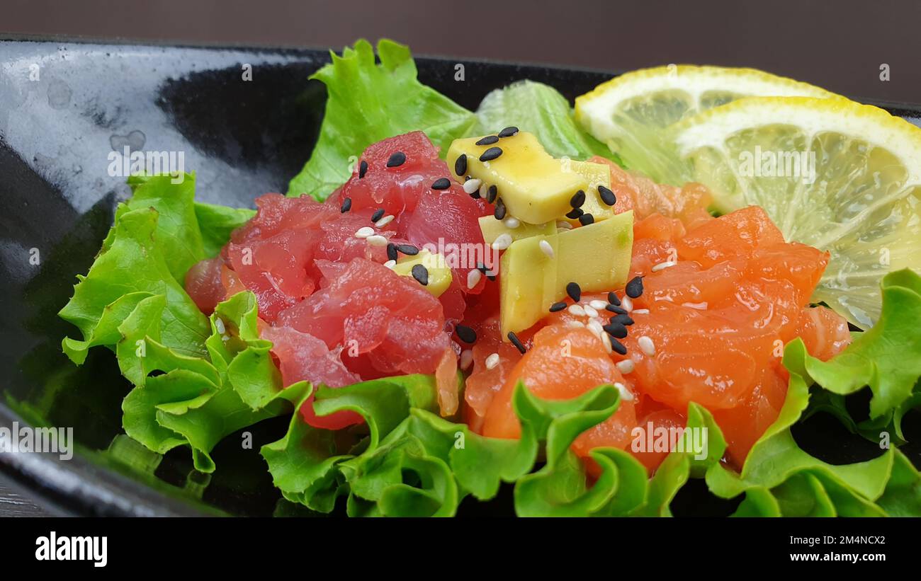 A closeup shot of a tuna Salmon Tartare served on a black plate Stock ...