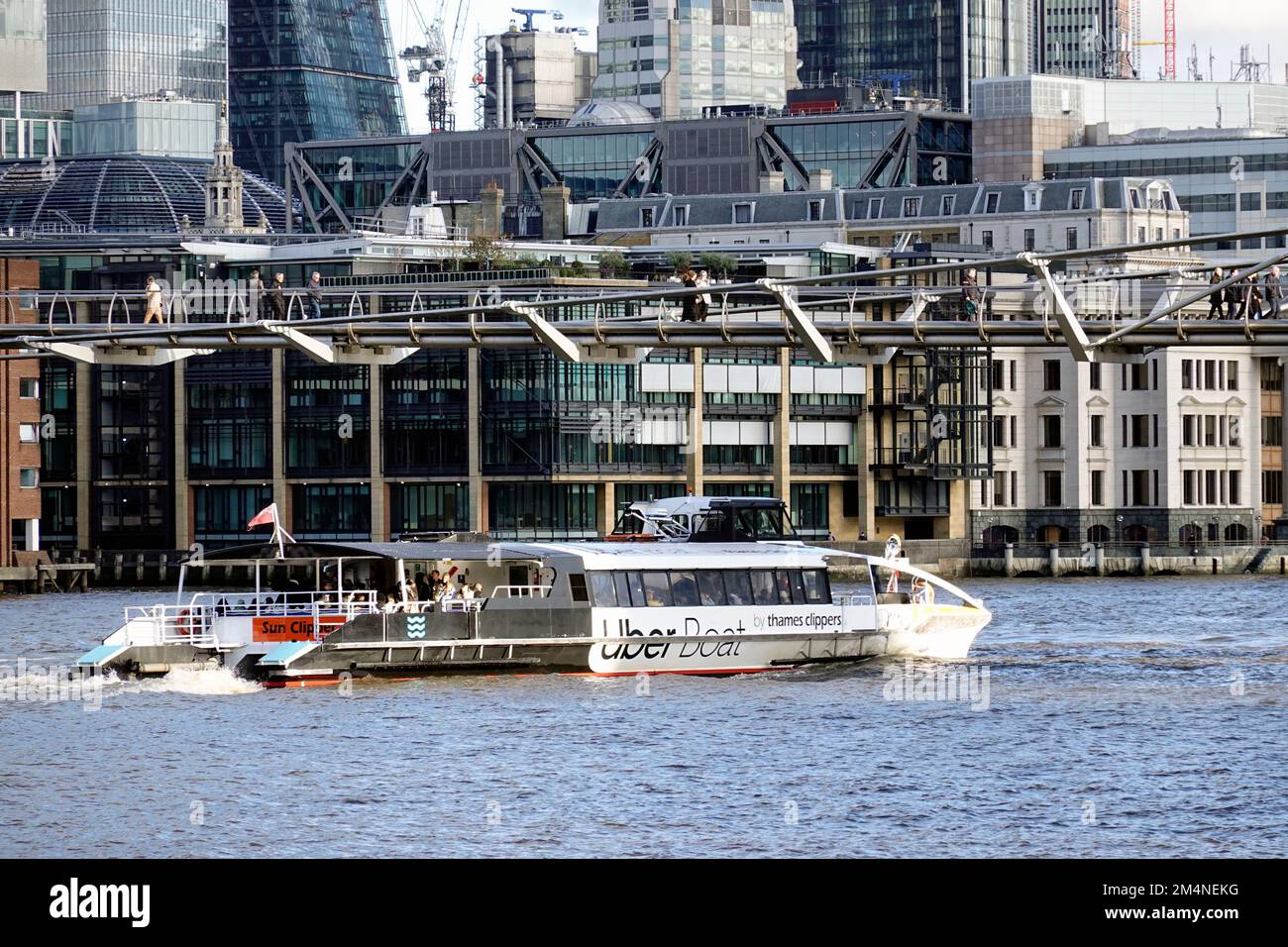 Passenger ferry passes the Millennial bridge in the city of London ...