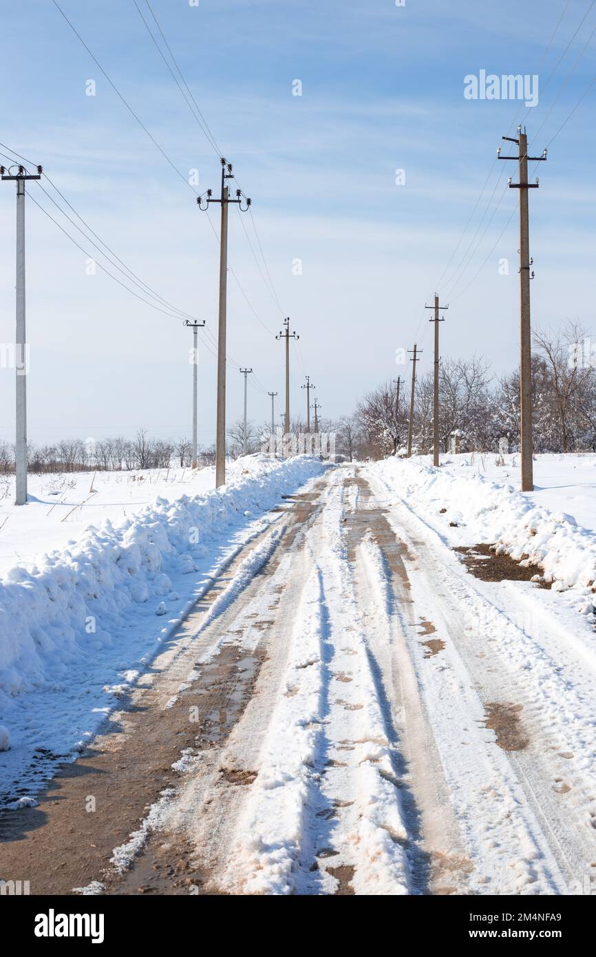 rural dirt road with fresh snow cleared and electric poles along the ...