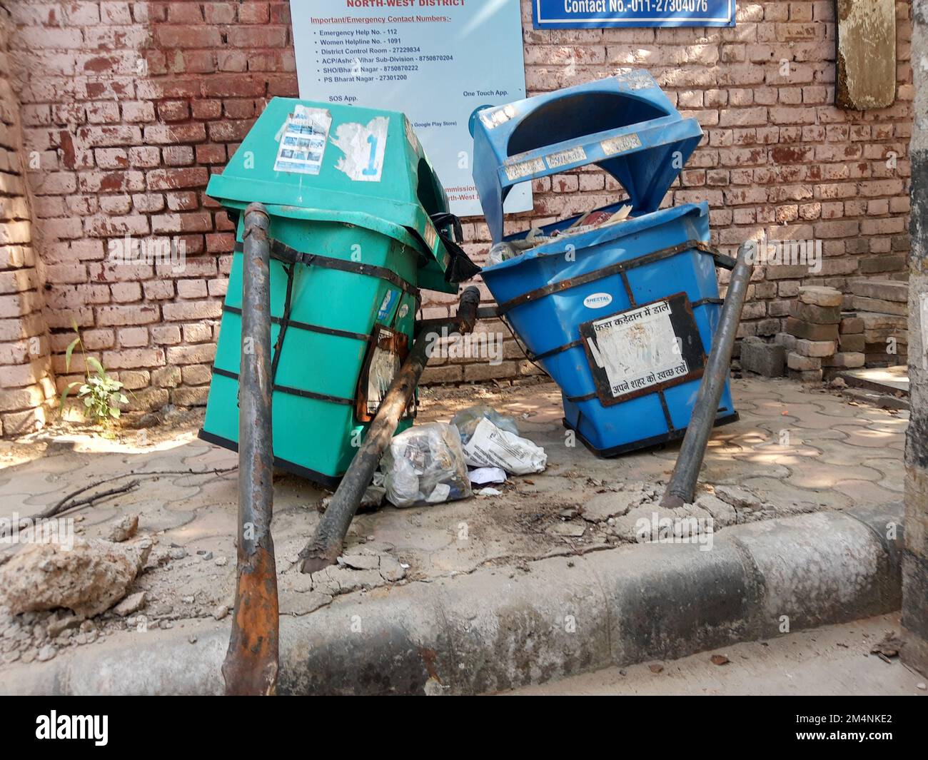 The broken and damaged plastic trash bins placed on steel pillars in ...