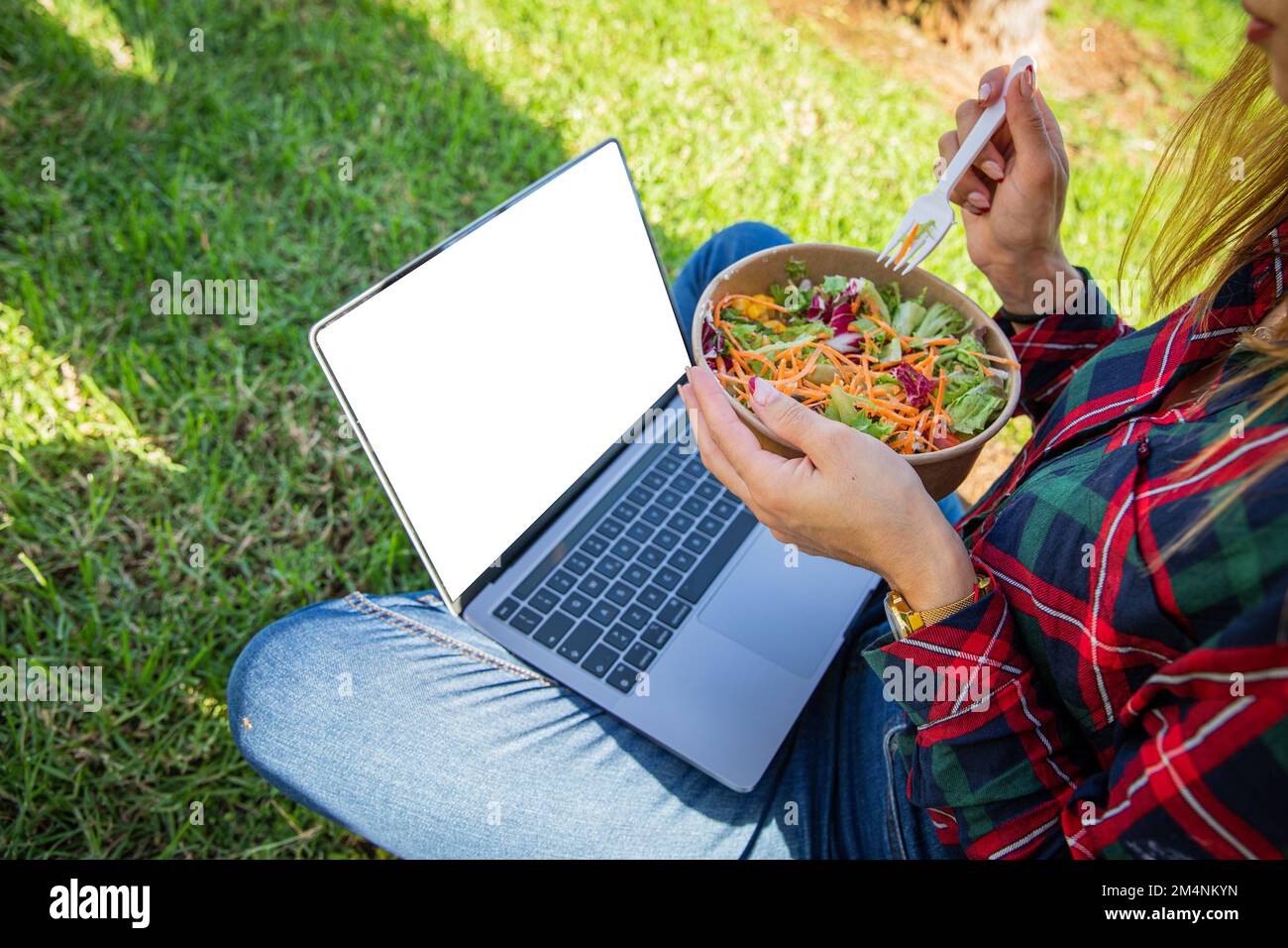 Mock up of a laptop screen used by a girl while eating a salad, vegan ...