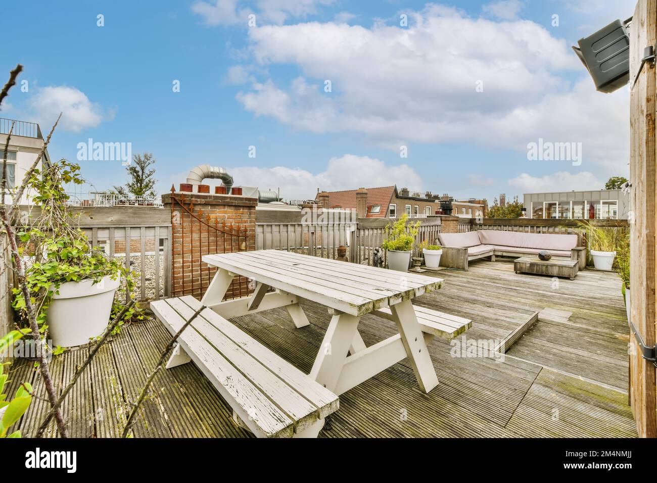 an outdoor area with wooden decking and white picnic tables in the ...