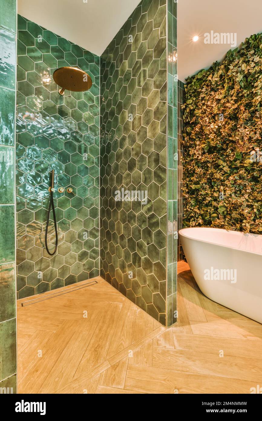a bathroom with green hexagon tiles on the walls and wood flooring ...