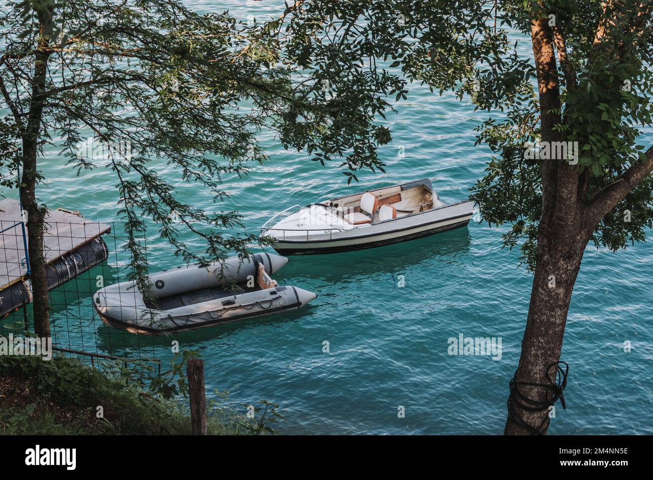 A Beautiful shot of a sailing boat on water behind trees Stock Photo ...