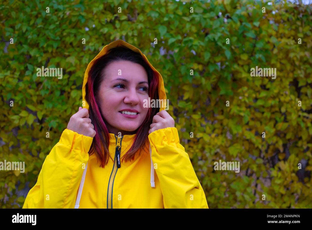 portrait of a girl in a yellow jacket against a background of trees ...