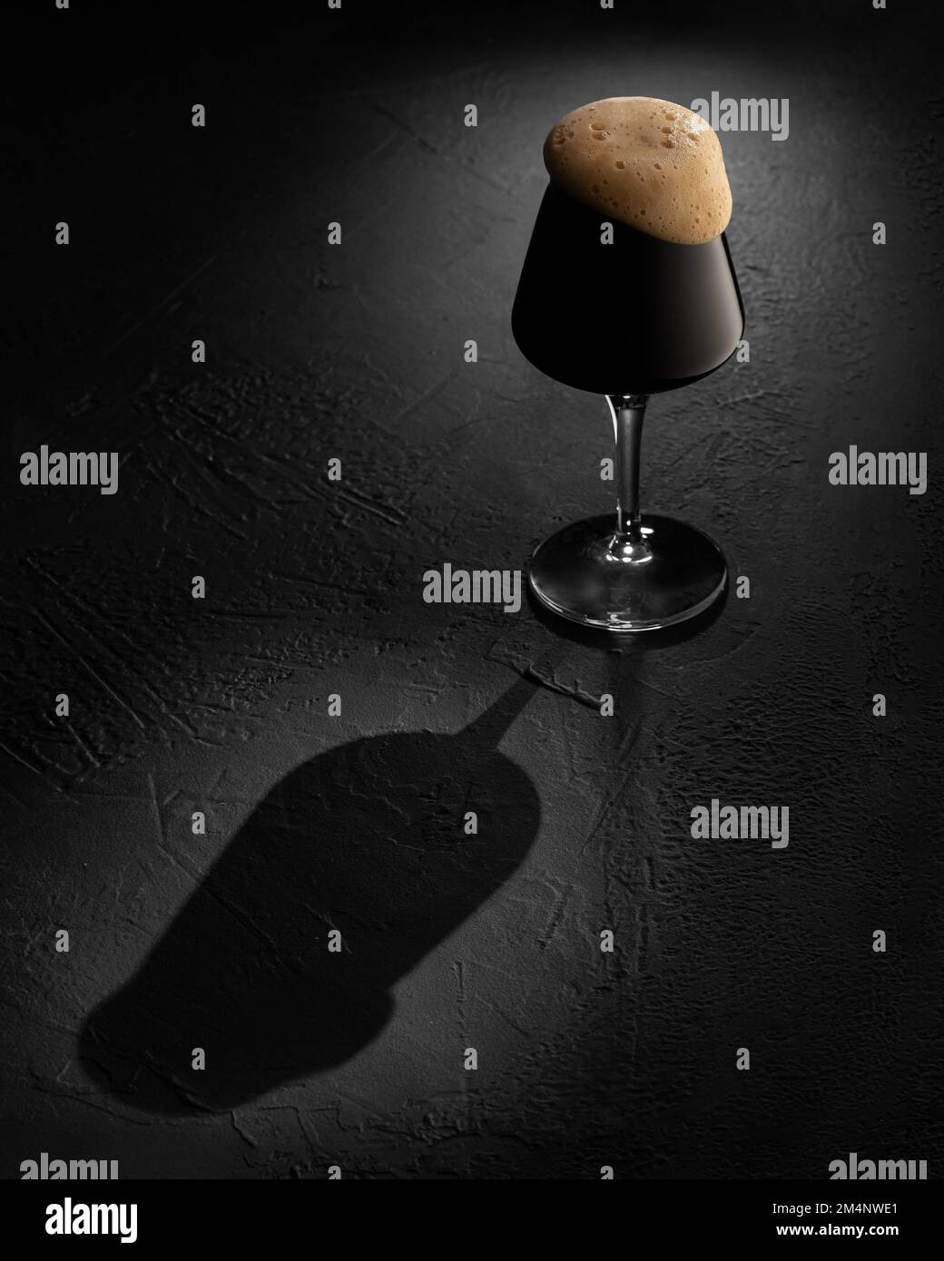 A Craft Beer Dark alcohol drink with a shadow on black backdrop Stock ...