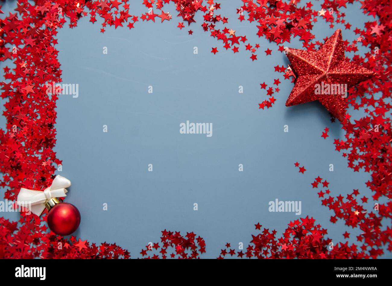 Blue Christmas background with red ball, star, glitter confetti and ...
