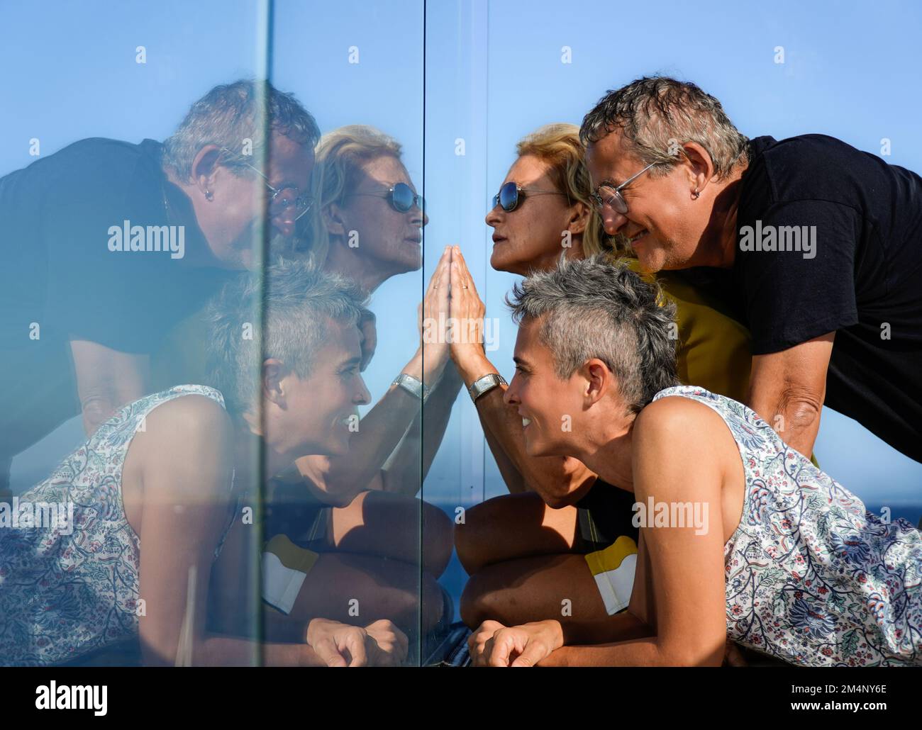 a family smiles and looks at their reflection in a mirror. real and ...