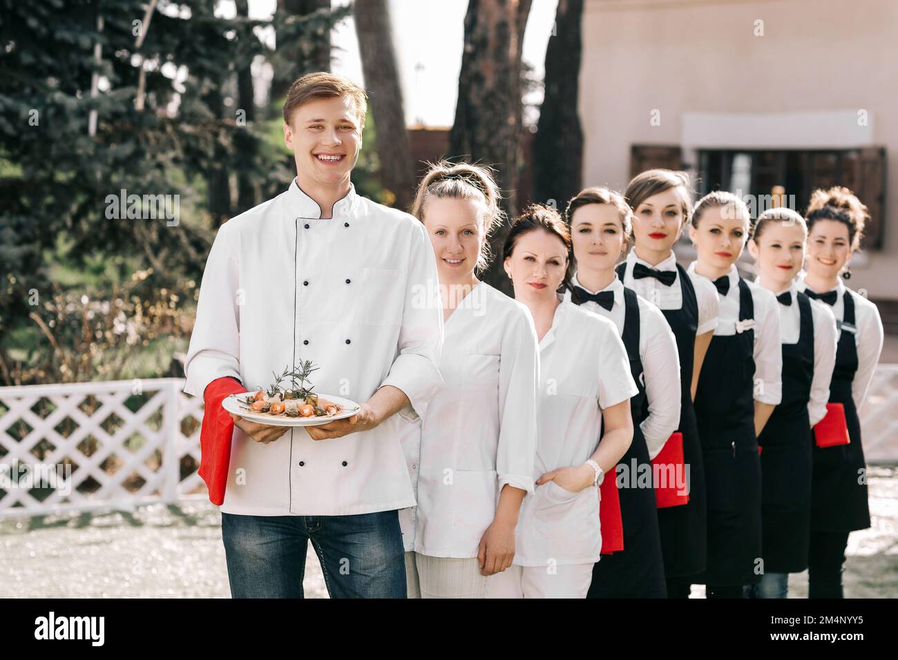 restaurant staff standing on the lawn near the restaurant Stock Photo ...