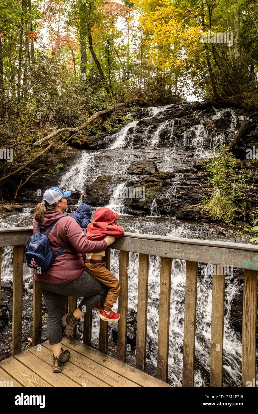 Mother holds her two young sons up to see waterfall from the viewing ...