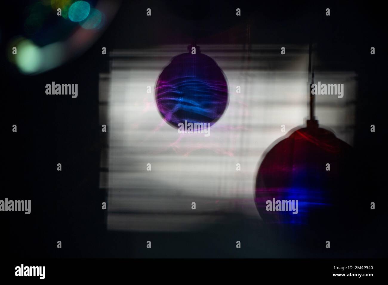 Glass hanging lights forming a colourful interesting shadow on a wall ...