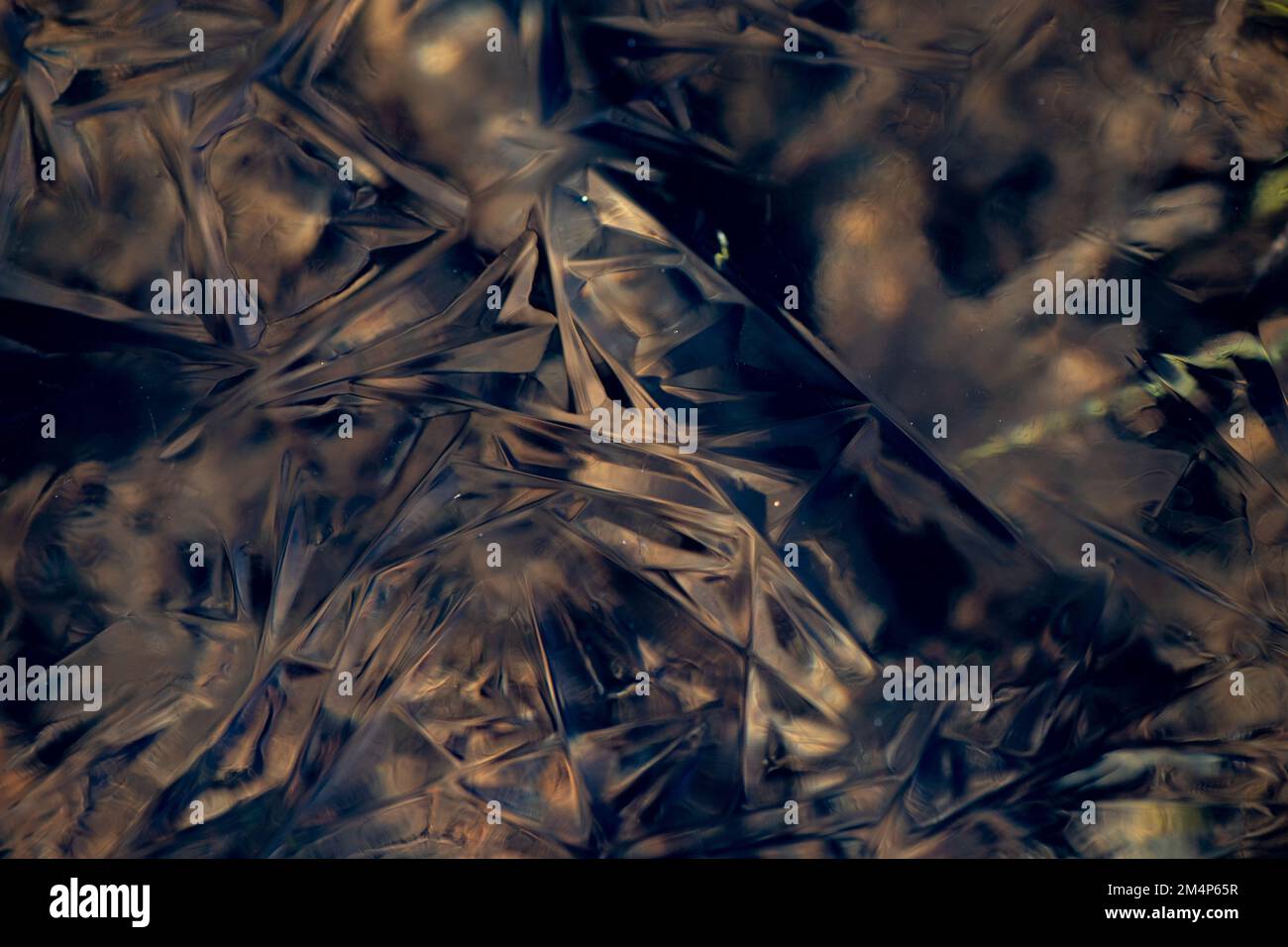 Close-up of Ice patterns captured in frozen stream in the New Forest ...
