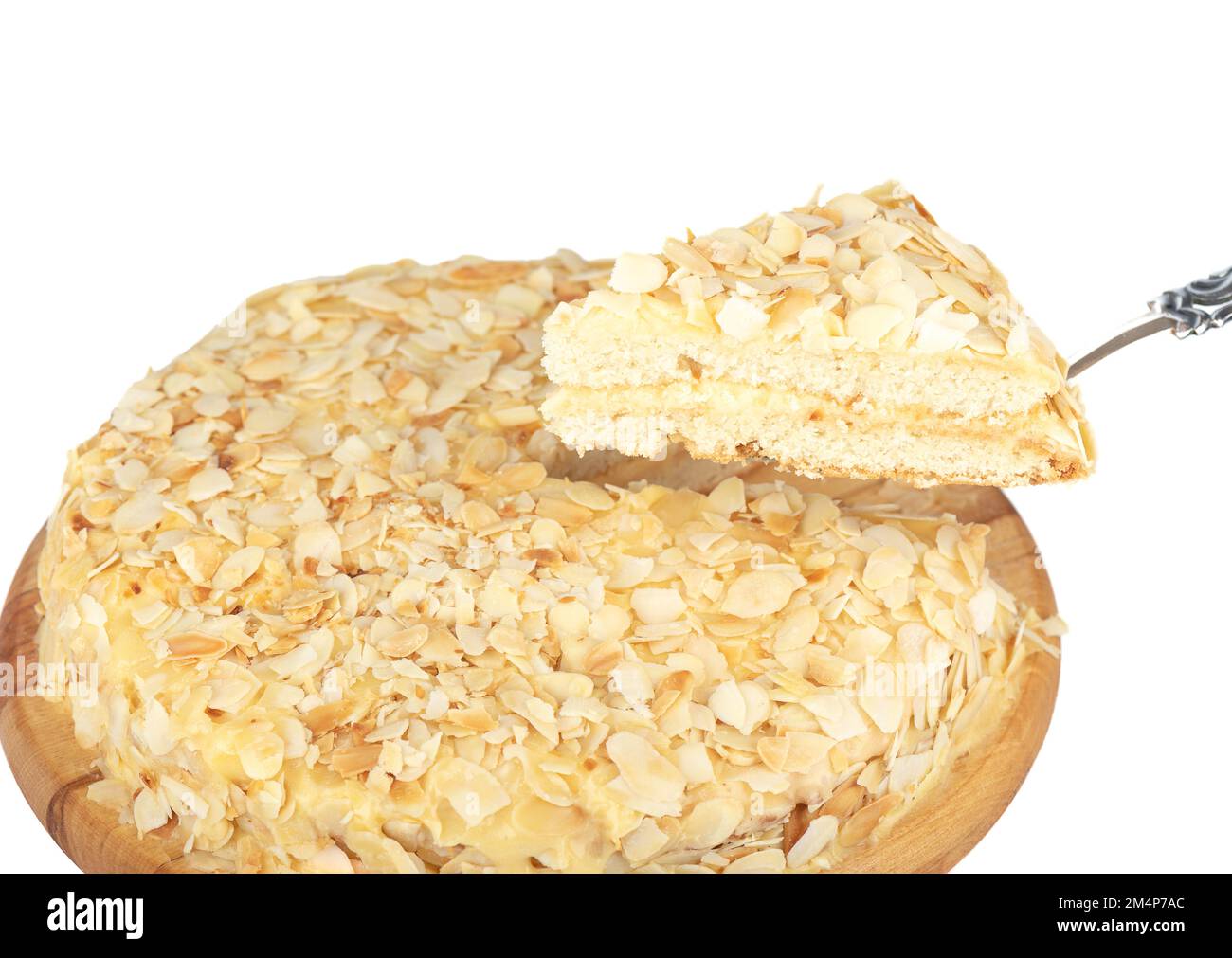 On a kitchen spatula, a slice of creamy Swedish almond cake topped with ...