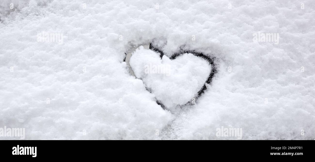 Heart shape love sign, drawn on a snow-covered ice with copy space ...