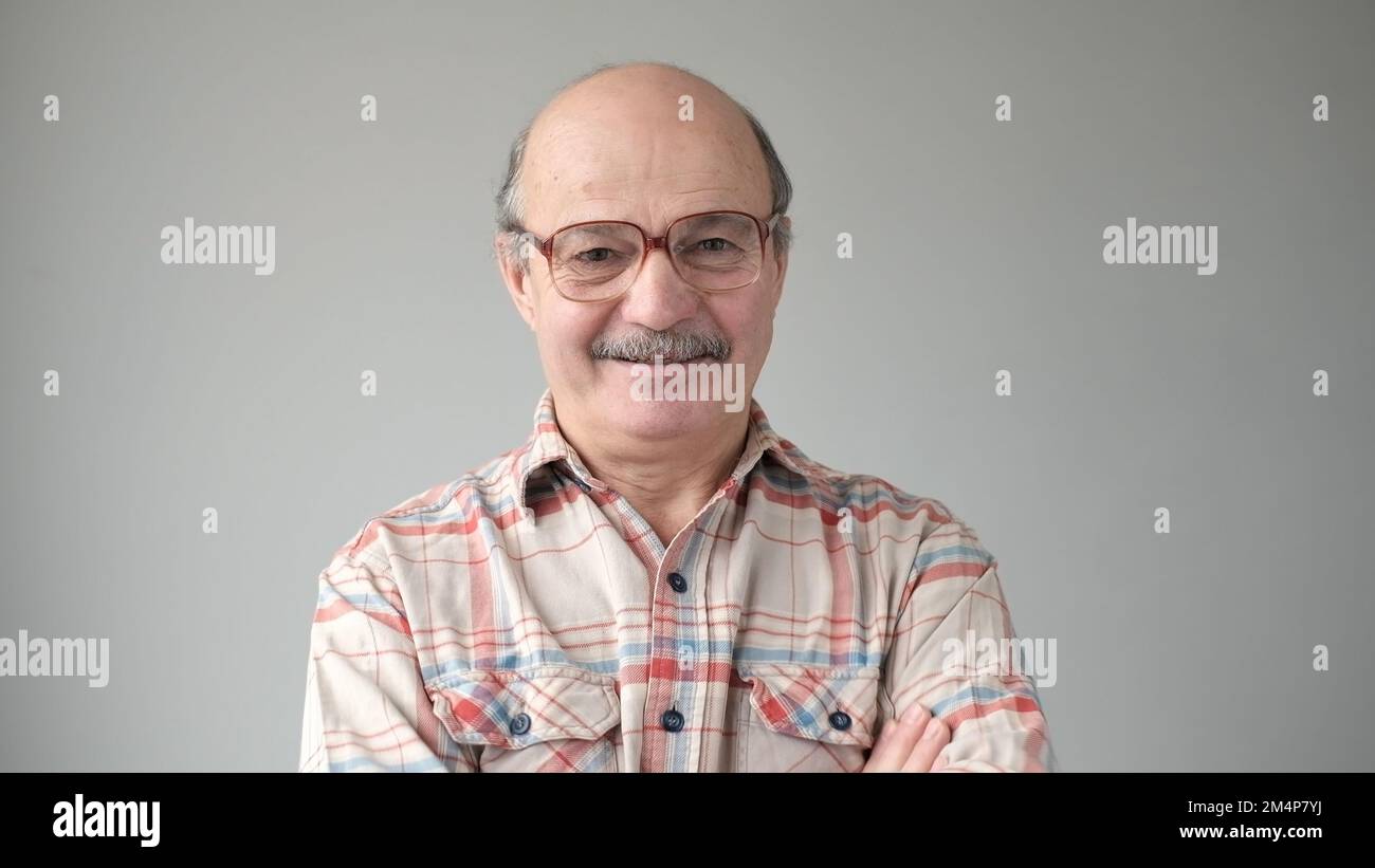 Portrait Of Smiling Mature Man Wearing Glasses Standing On White