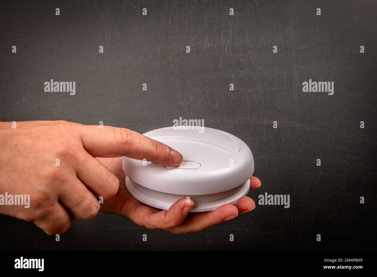 Fire alarm sensor in woman's hand. Test button Stock Photo - Alamy