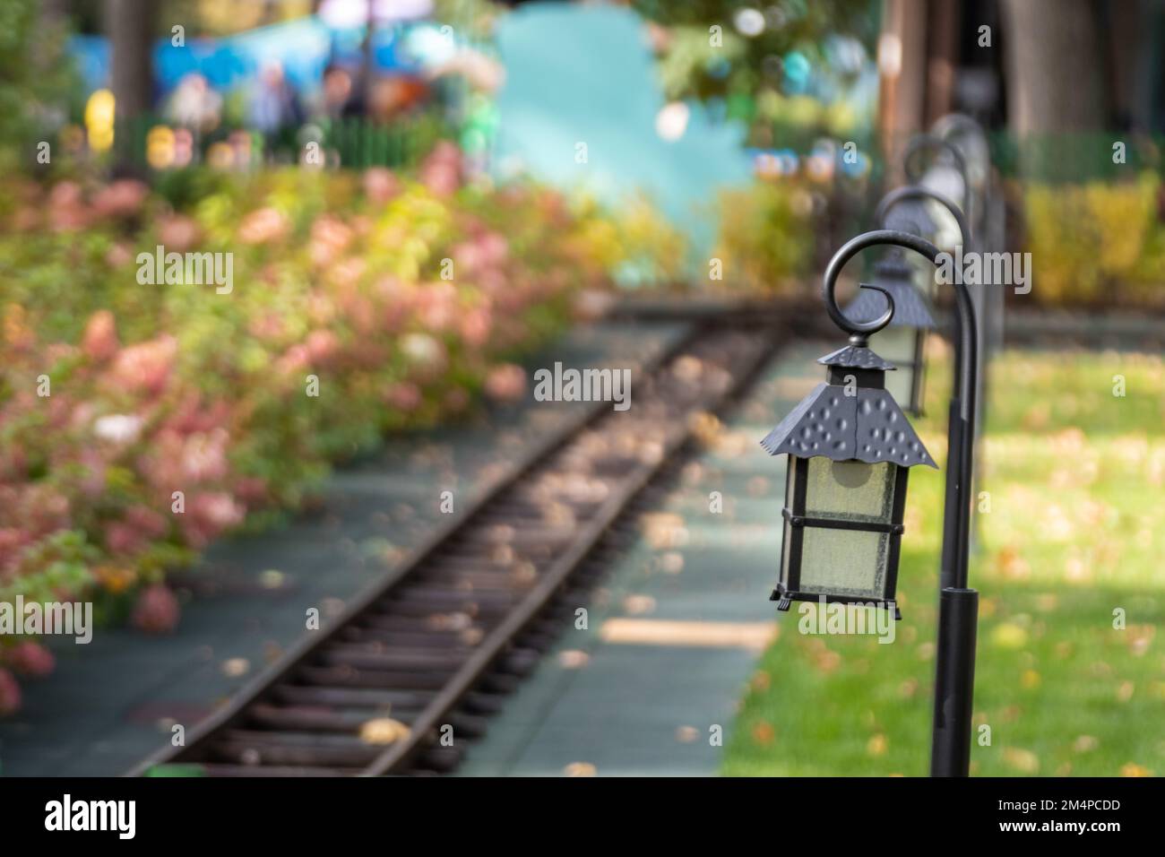 Outdoor entertainment railway attraction with lamp lanterns. Railway in ...