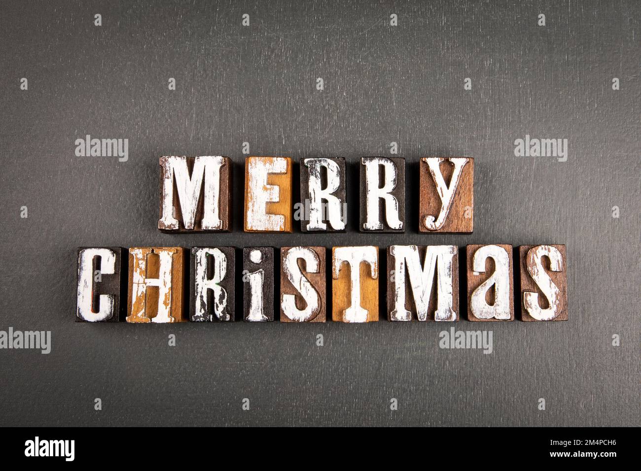 Merry Christmas. Text from wooden alphabet blocks on a dark chalkboard ...
