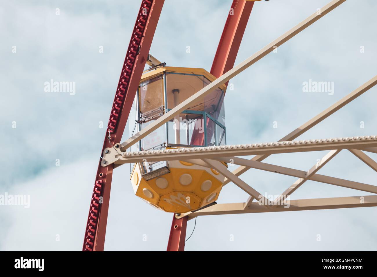 Yellow ferris wheel cabin close view on cloudy sky. Culture and ...