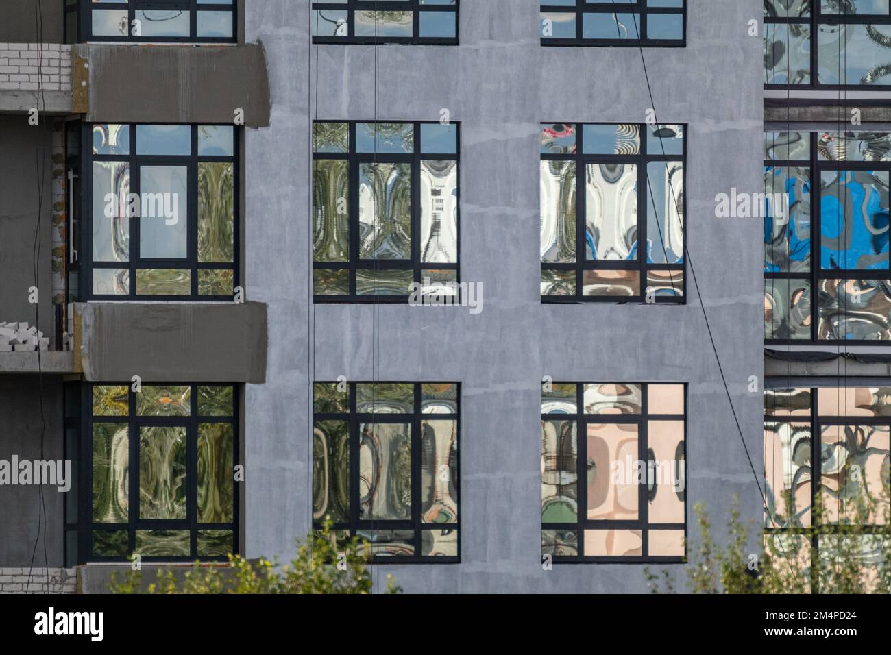 Multistory building gray facade with mirror windows, construction site ...