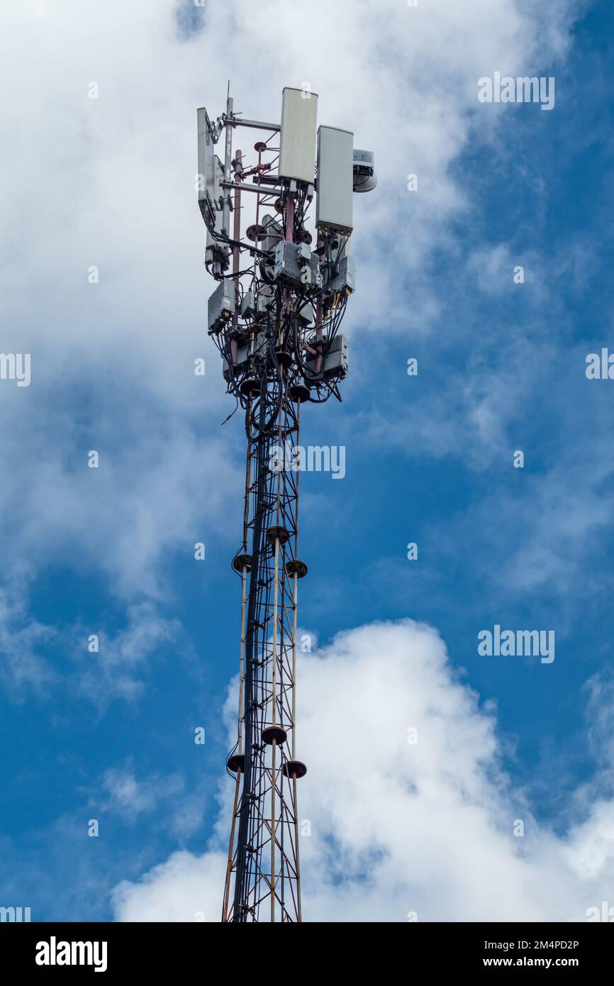 Mobile telecommunication tower with antennae and electronic communications equipments on blue ...